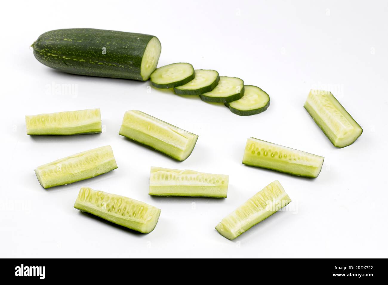 A close up photo of whole, sliced, and cut up pieces of cucumber on a ...