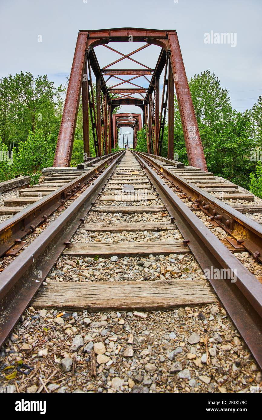 Low view of train tracks leading to rusty iron railroad bridge on Heart ...