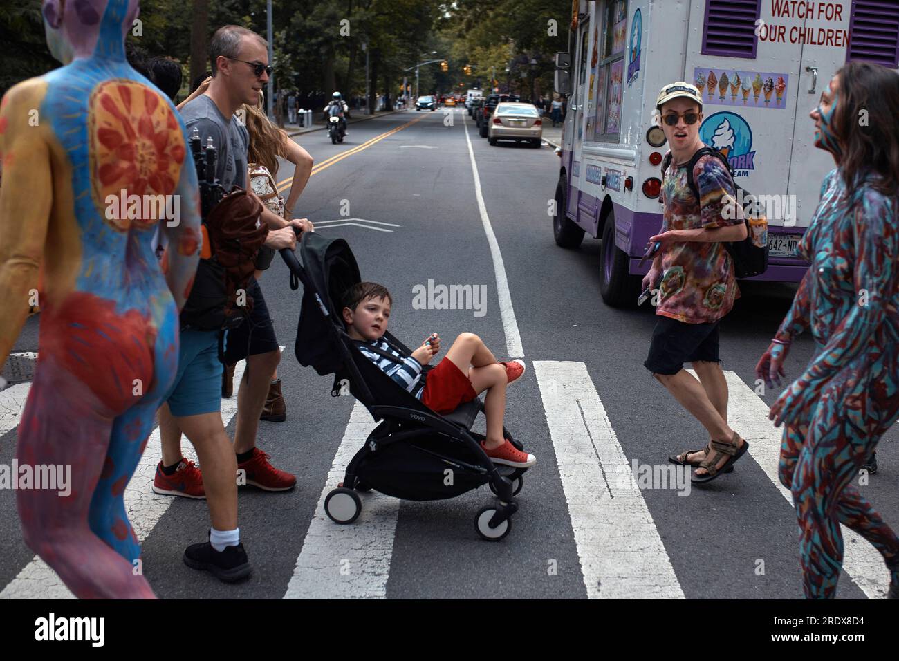 EDS NOTE: NUDITY - A family passes by as models painted by an artist walk during the Human ...