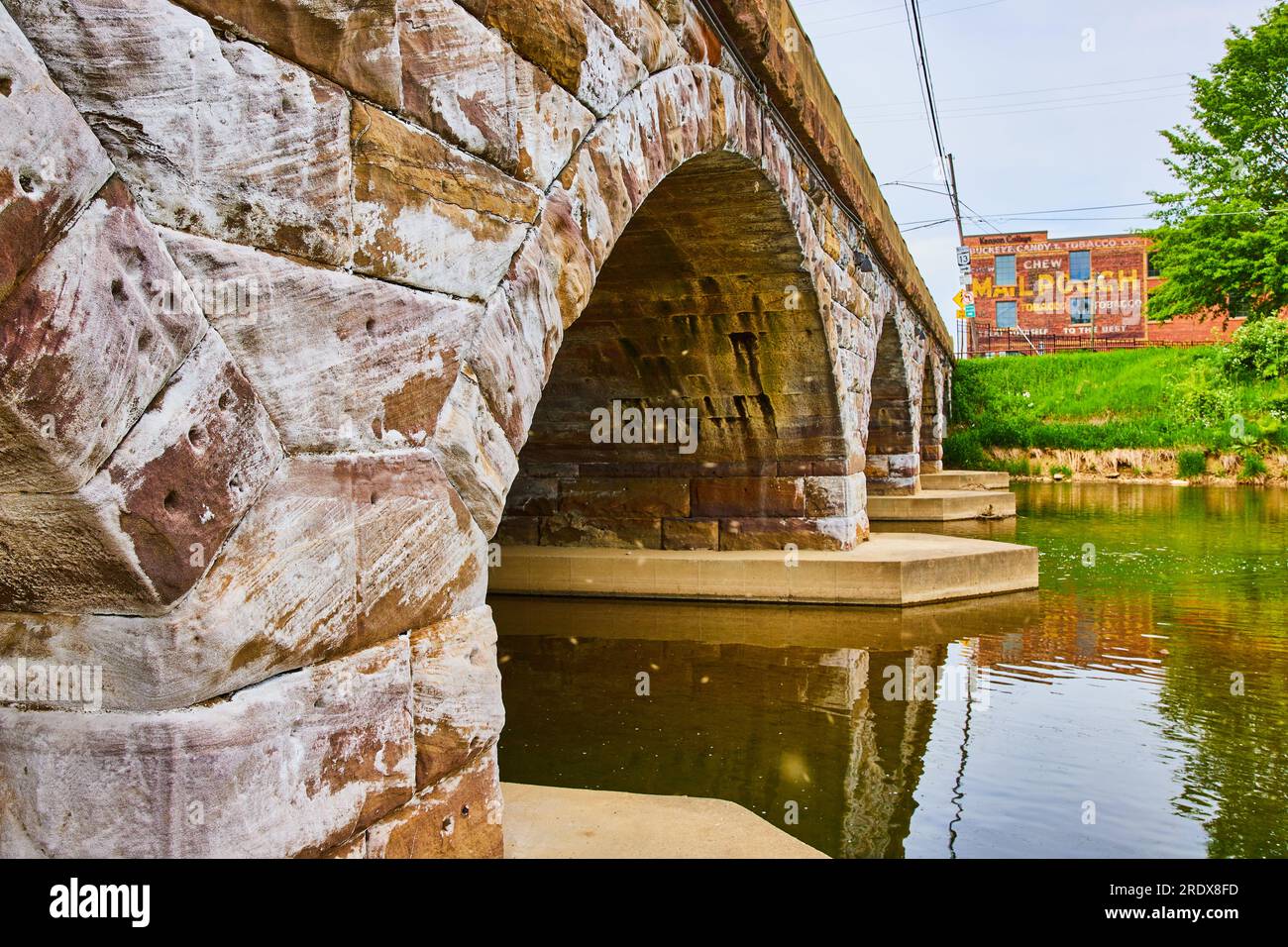 River flowing under white on stone bricks of earth tone golden hues and ...