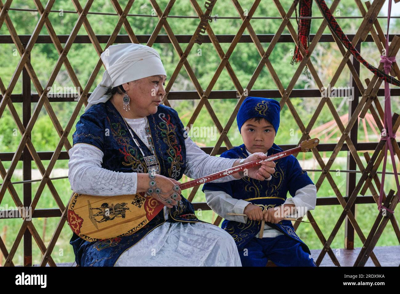 Kazakhstan, Huns Ethno Village. Kazakh Woman in Traditional Dress Playing the Dombra Stock Photo ...