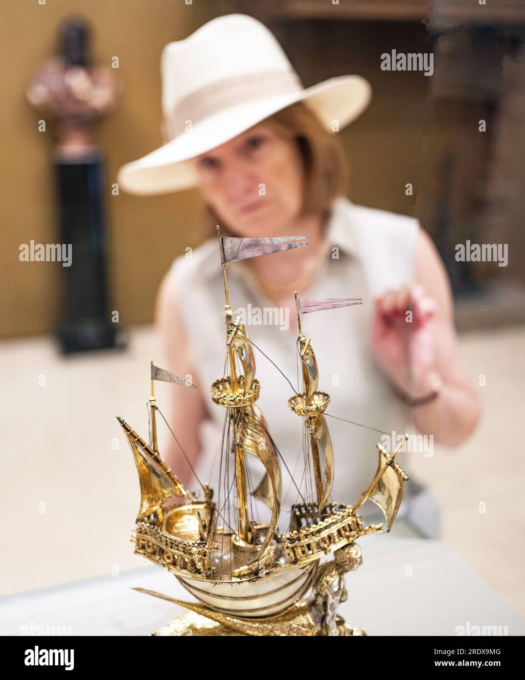 Woman behind museum case looking at the Burghley Nef (1528), an ...