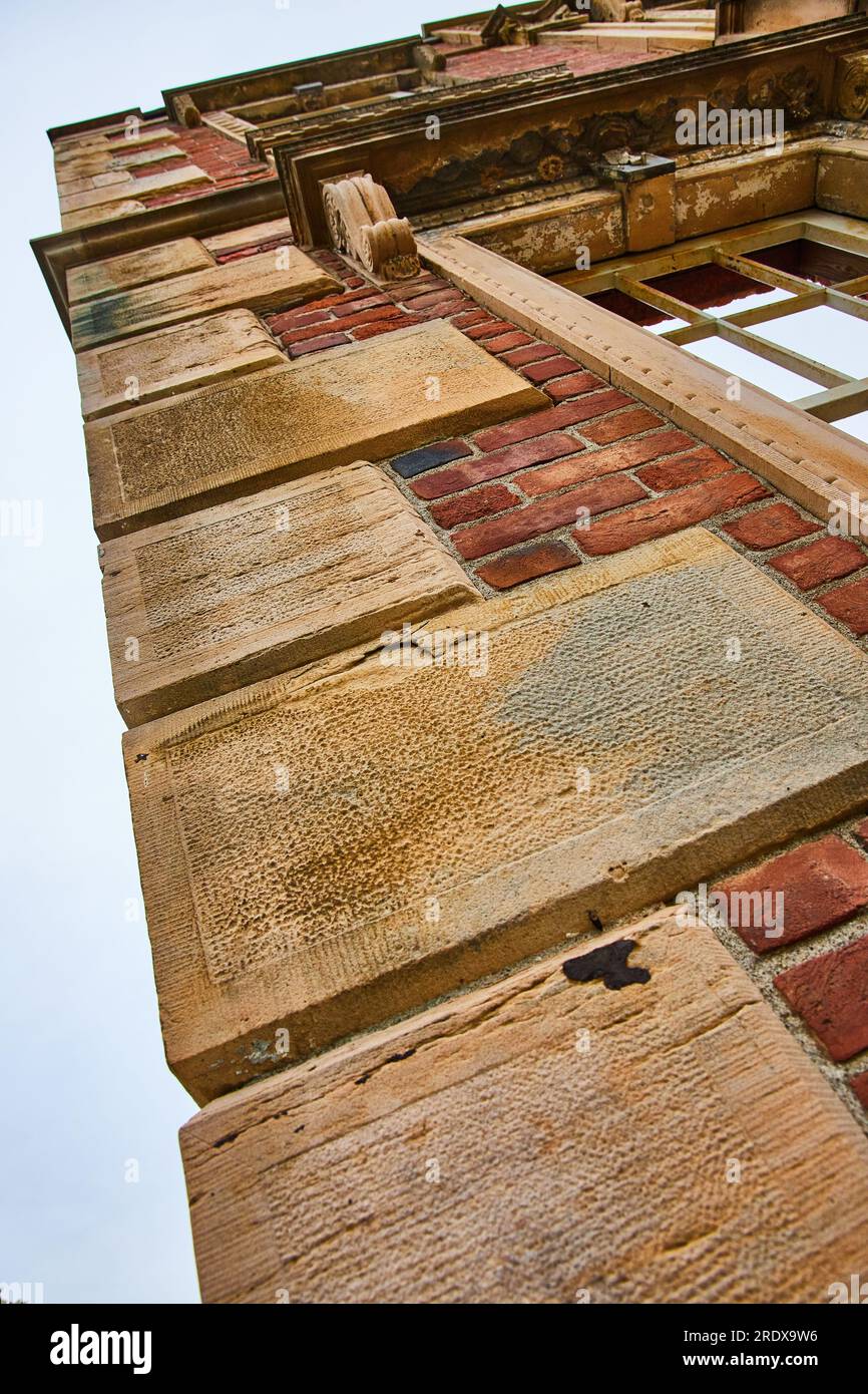 Vertical view of side of abandoned red brick mansion building and open ...