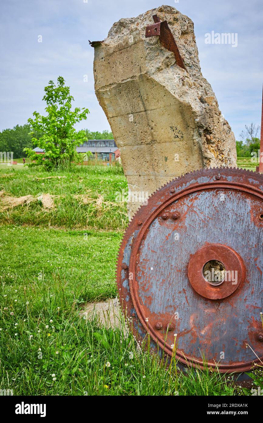 Rusty metal cog resting against busted concrete pillar with exposed ...