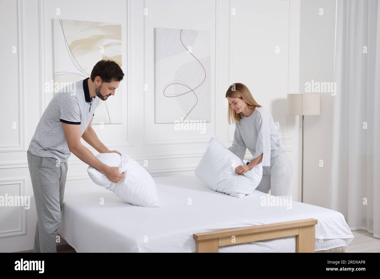 Couple changing bed linens at home. Domestic chores Stock Photo - Alamy