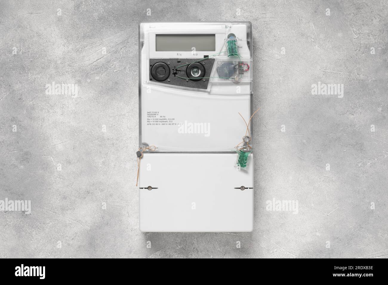 Electricity meter on light grey wall. Measuring device Stock Photo - Alamy