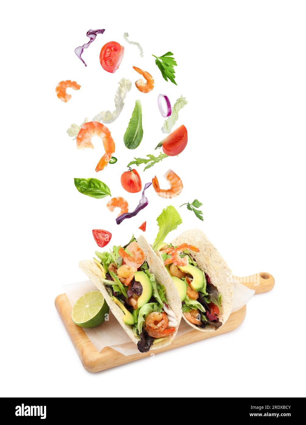 Delicious tacos. Ingredients falling into tortillas on white background ...