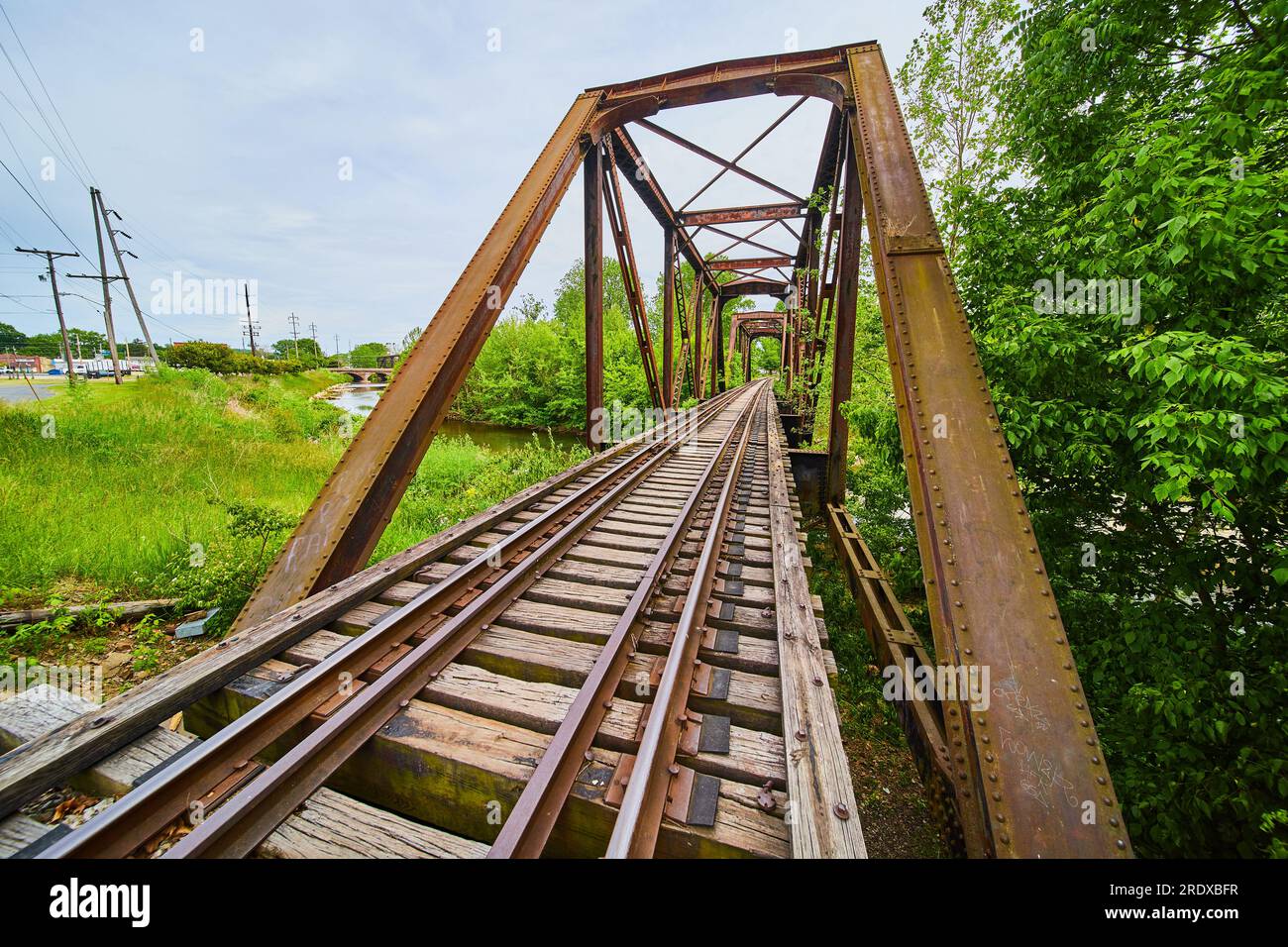 Rusty truss iron railroad bridge with train tracks over Kokosing River ...