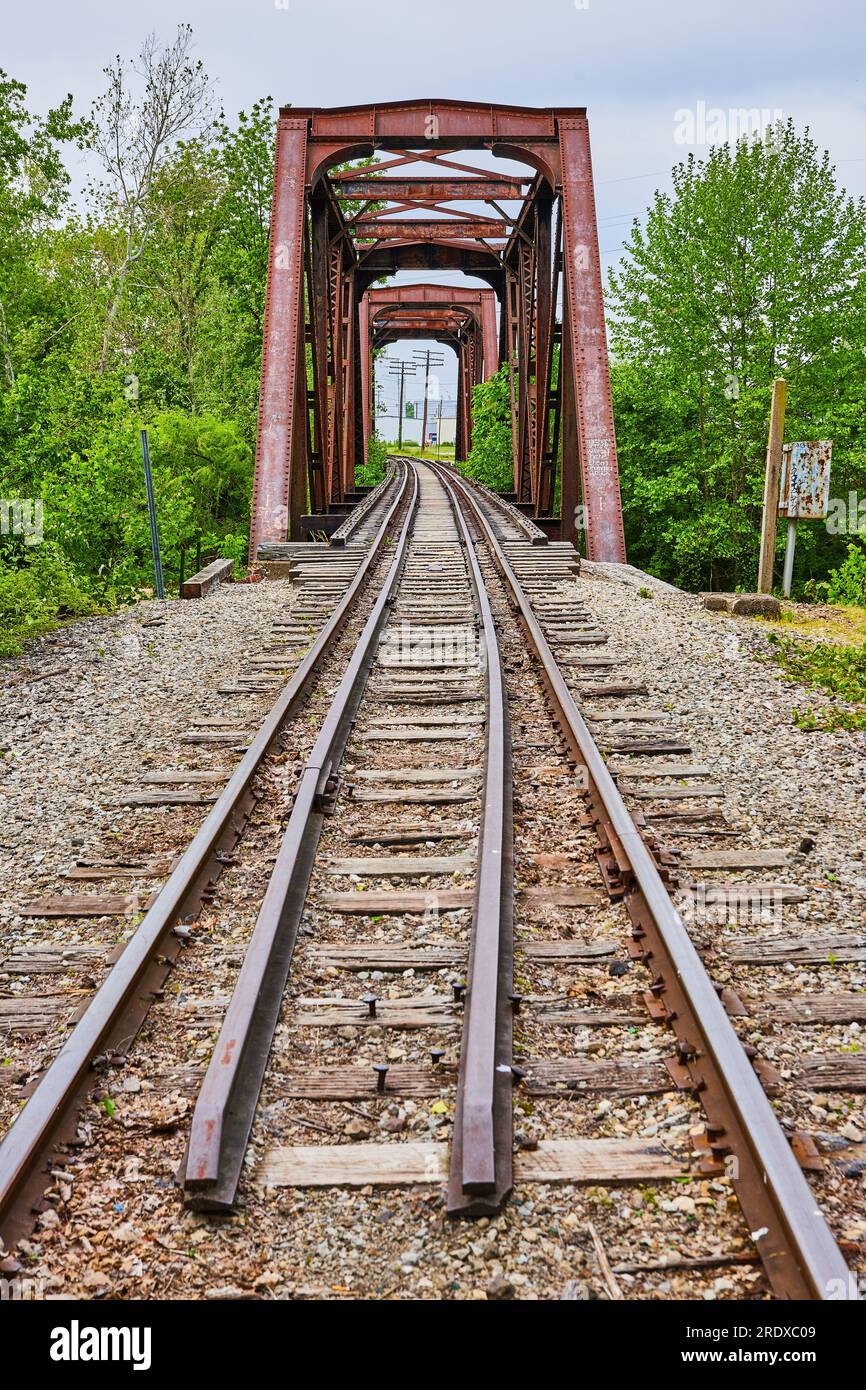 End of middle train track with outer railroad track through rusty iron ...