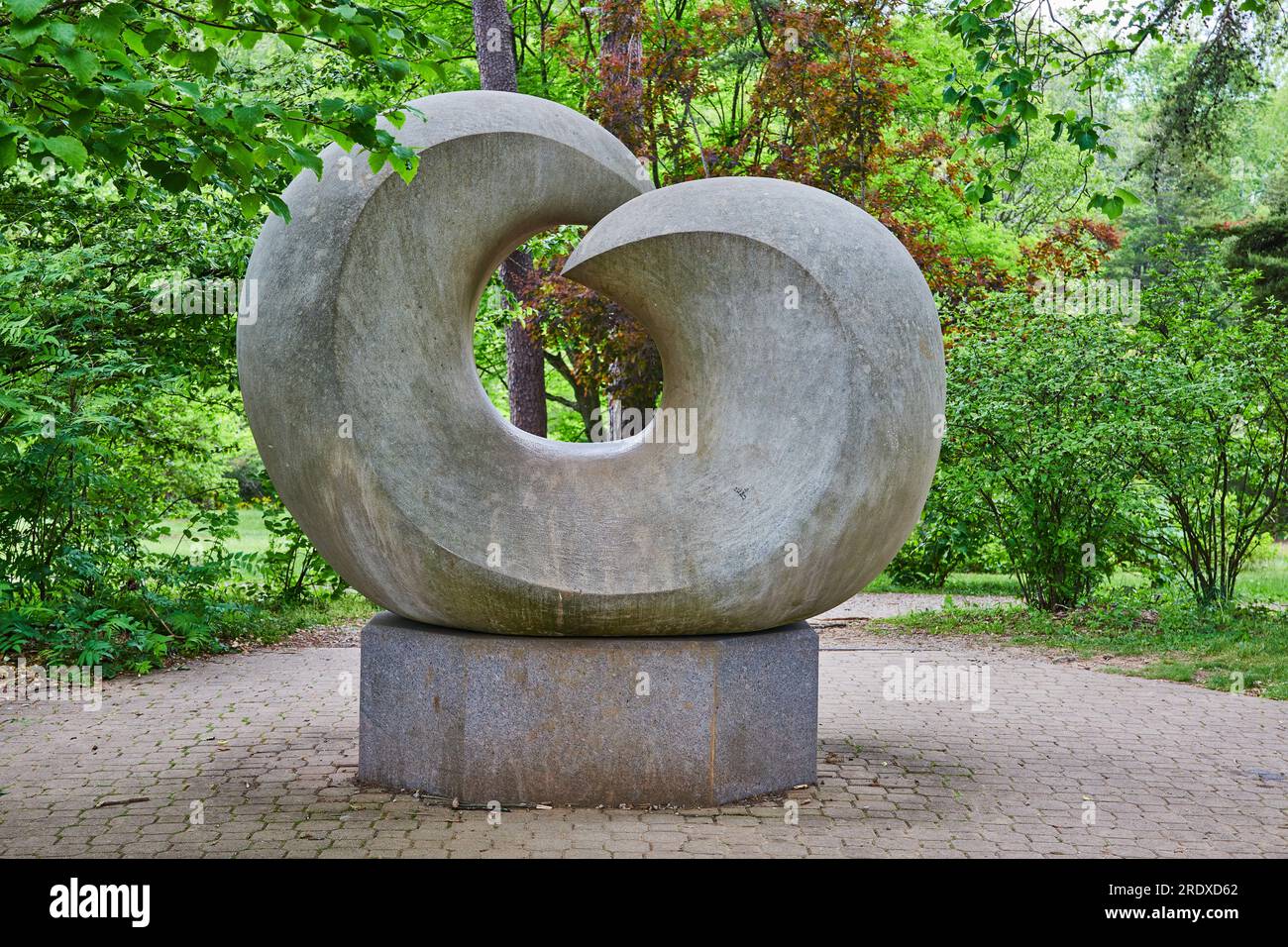 Abstract art stone sculpture of curving rock on cobblestone path with ...