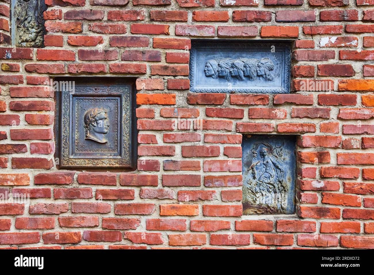 Tall red brick wall with multiple cultural motifs and cameos background ...