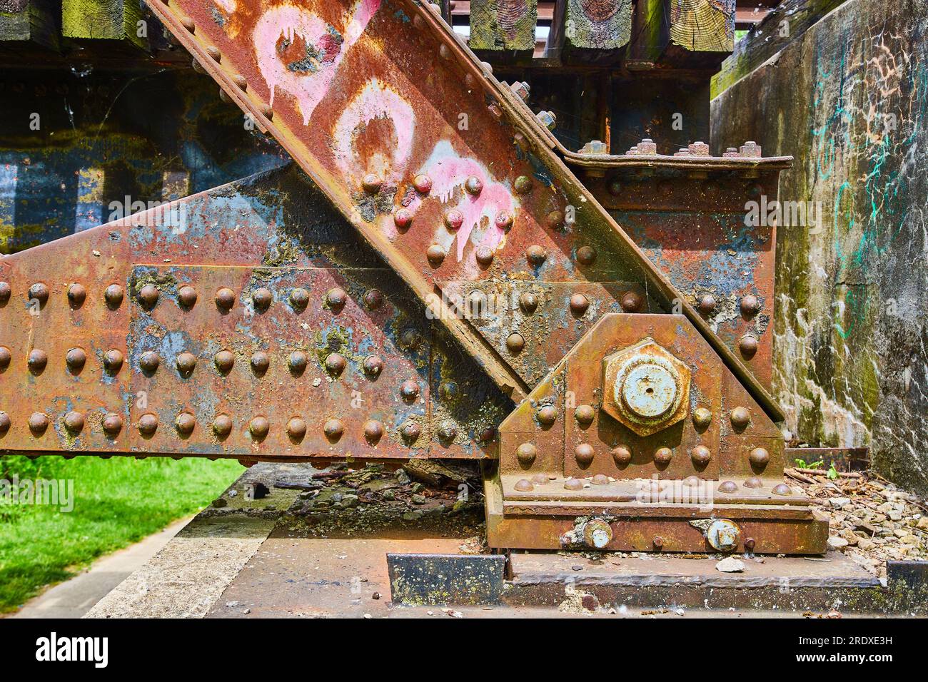 Rusty metal rivets on railroad bridge side view and pink graffiti with ...