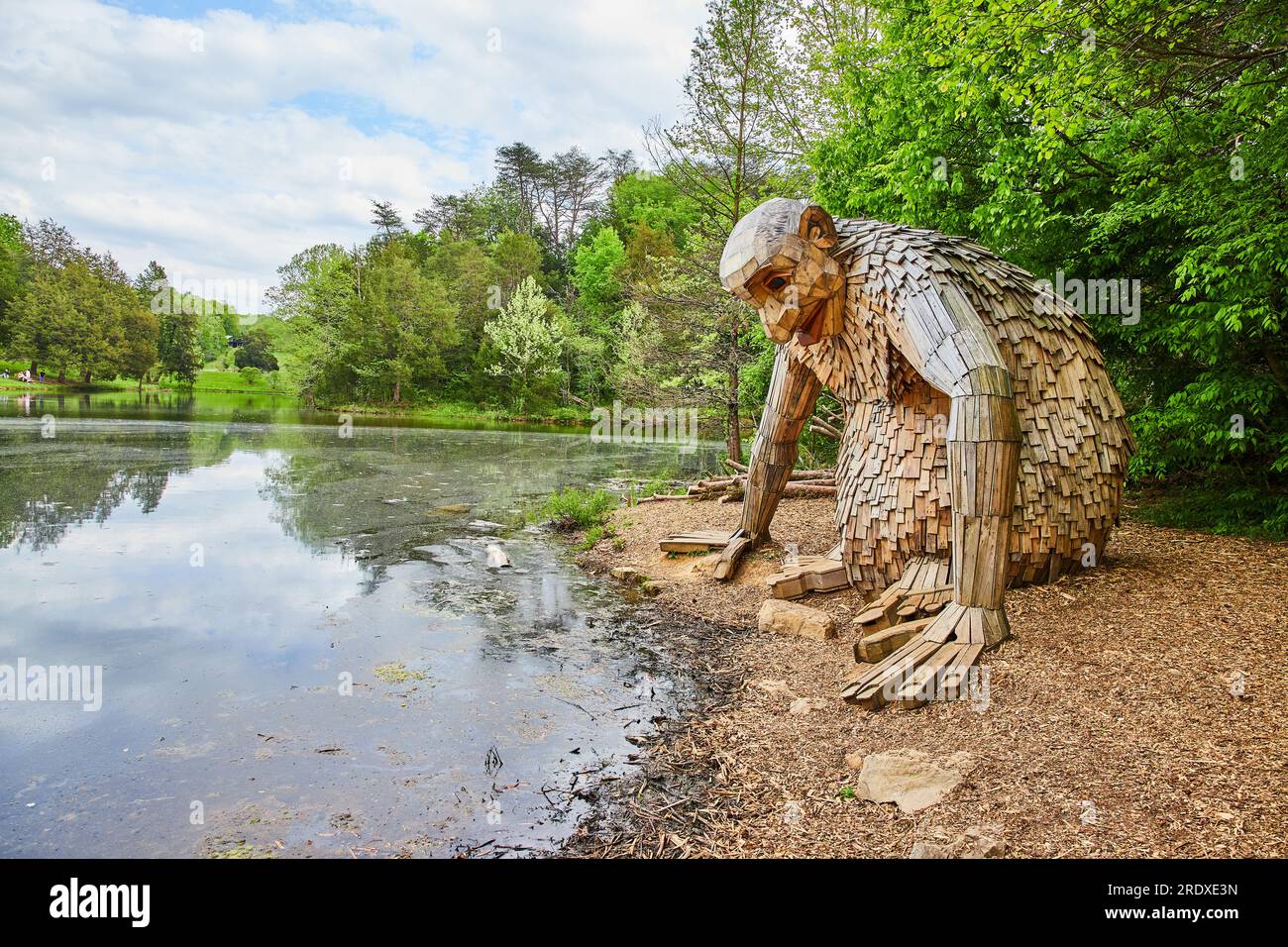Sad giant Little Nis looking at reflection in dirty pond water outside ...