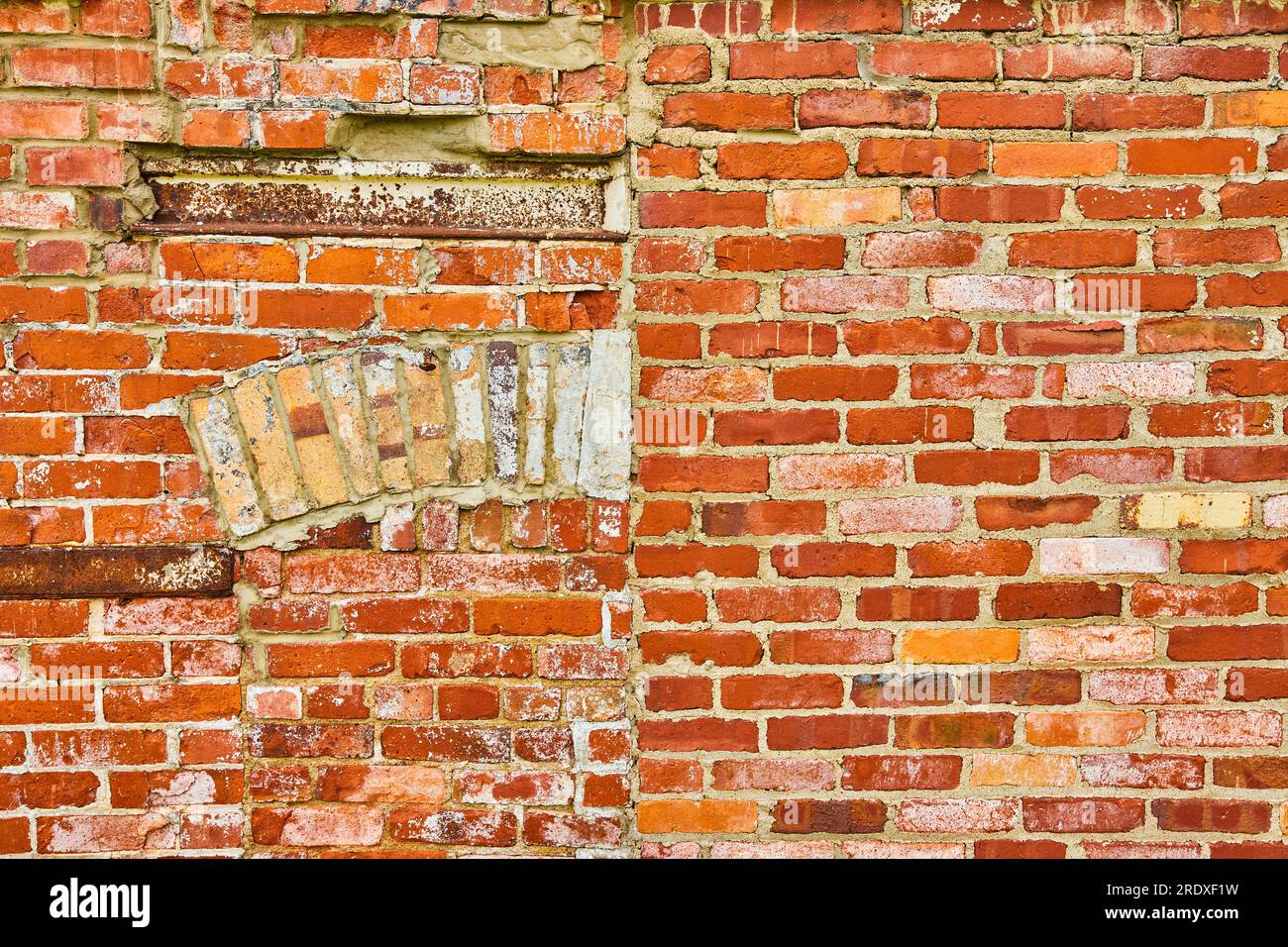 Split wall of regular red bricks versus decaying wall of mismatching ...