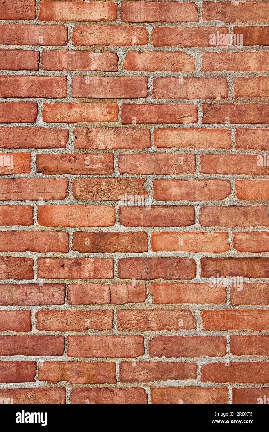 Vertical clean but faded red brick wall textured and faded by time ...