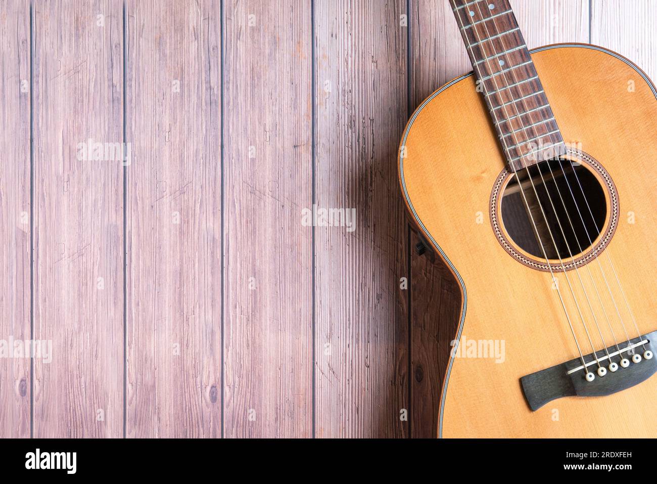 Acoustic guitar resting on rustic wooden background. Copy space Stock ...