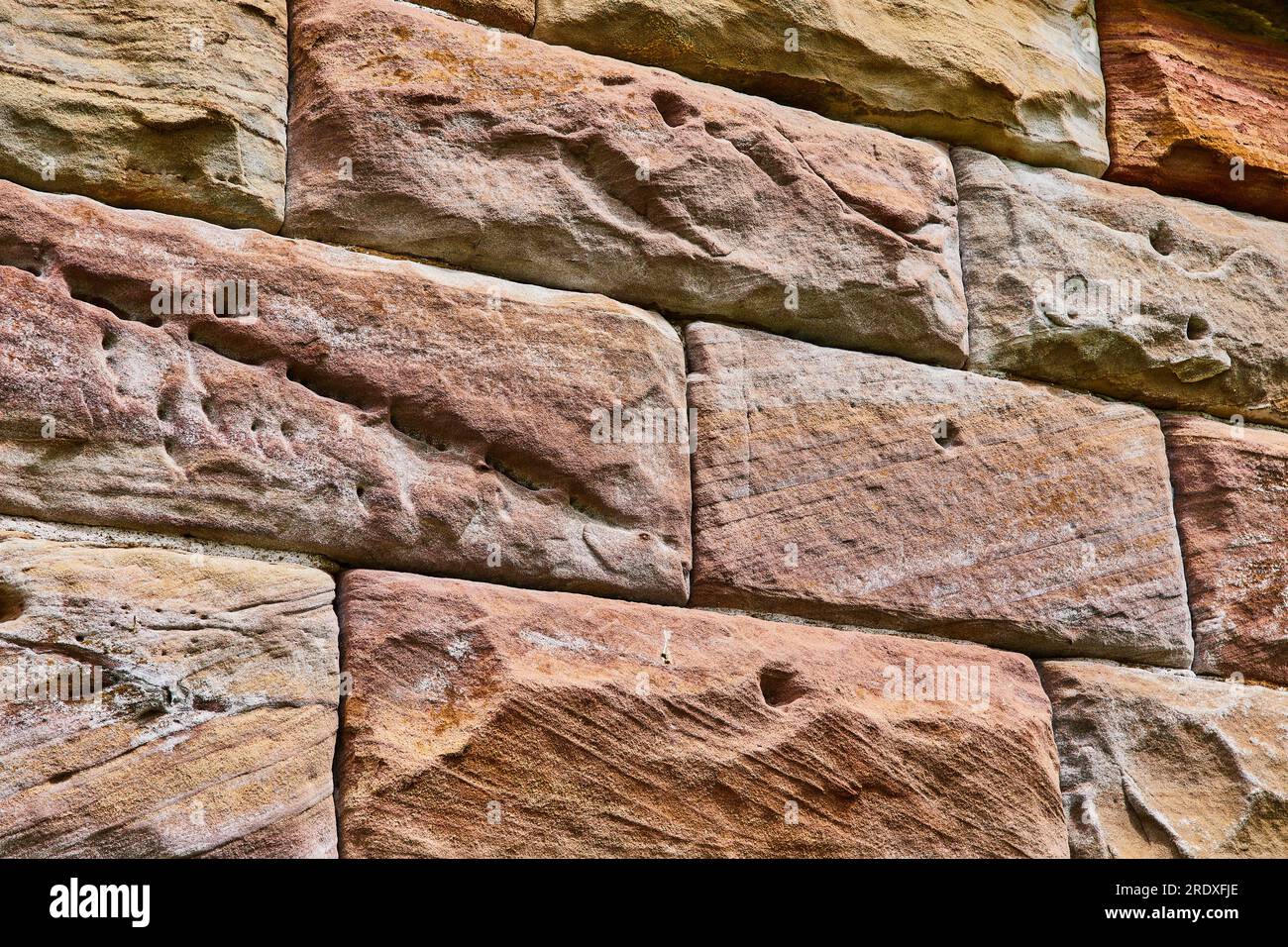 Large textured stone brick wall with earth tone hues and rustic red ...