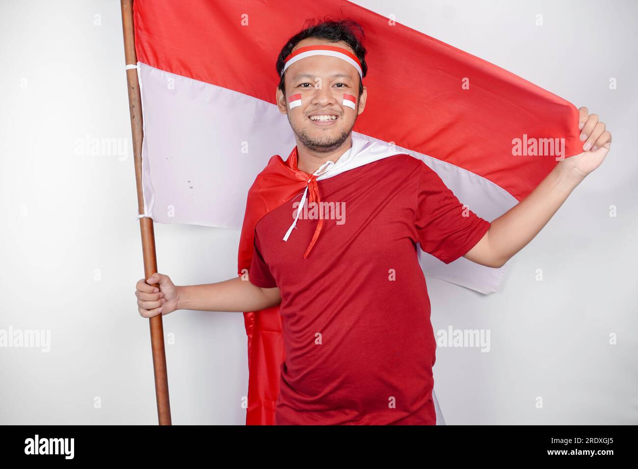 Happy smiling Indonesian man holding Indonesia's flag to celebrate ...