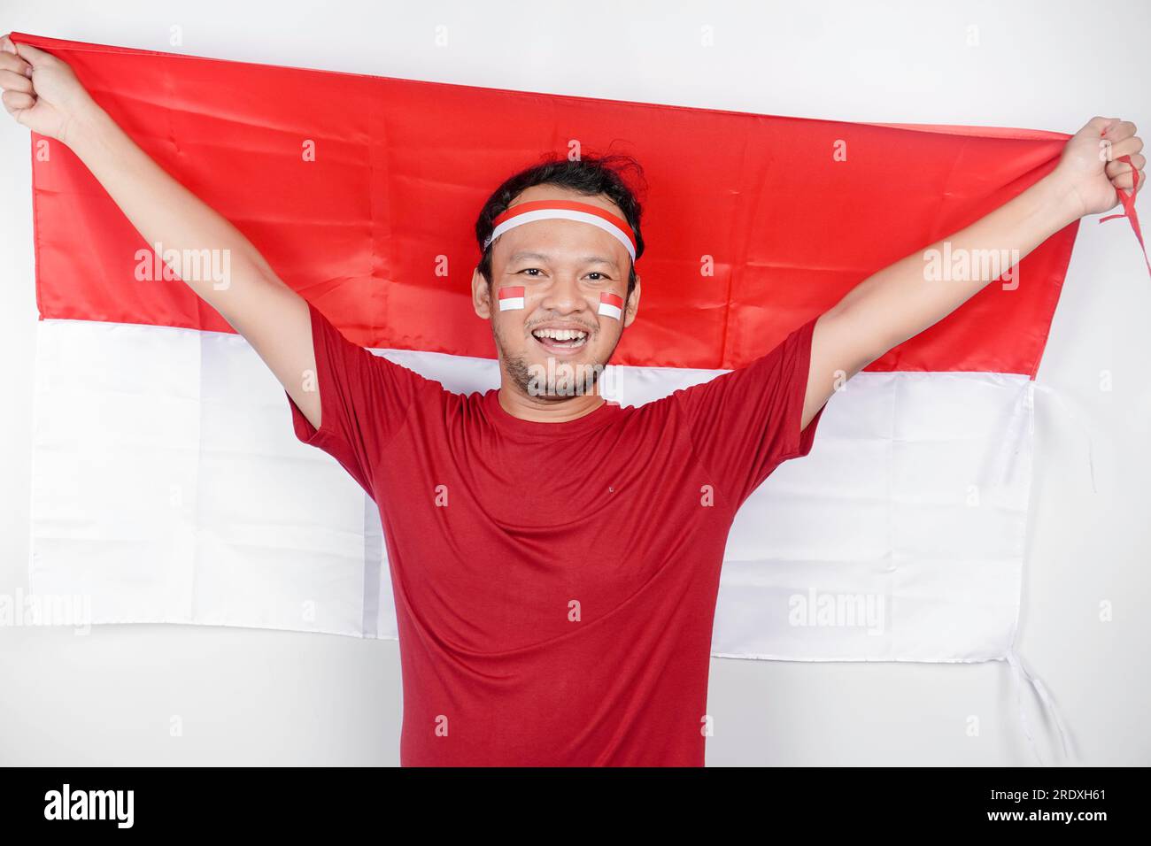 Happy smiling Indonesian man holding Indonesia's flag to celebrate ...