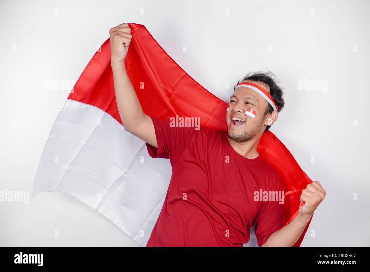 Happy smiling Indonesian man holding Indonesia's flag to celebrate ...