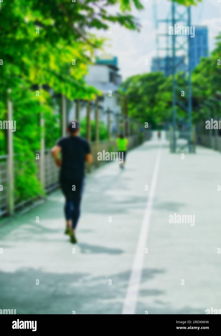 Vertical blurred image of people jogging on the skywalk which connects ...