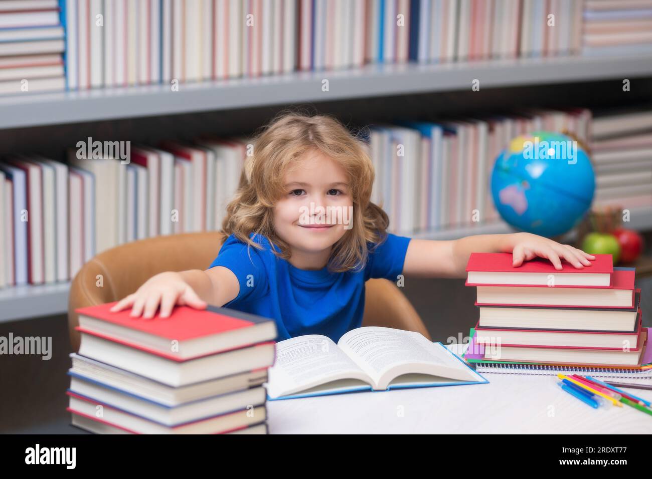 Smart pupil. School kid pupil studying in school library. Child reading ...