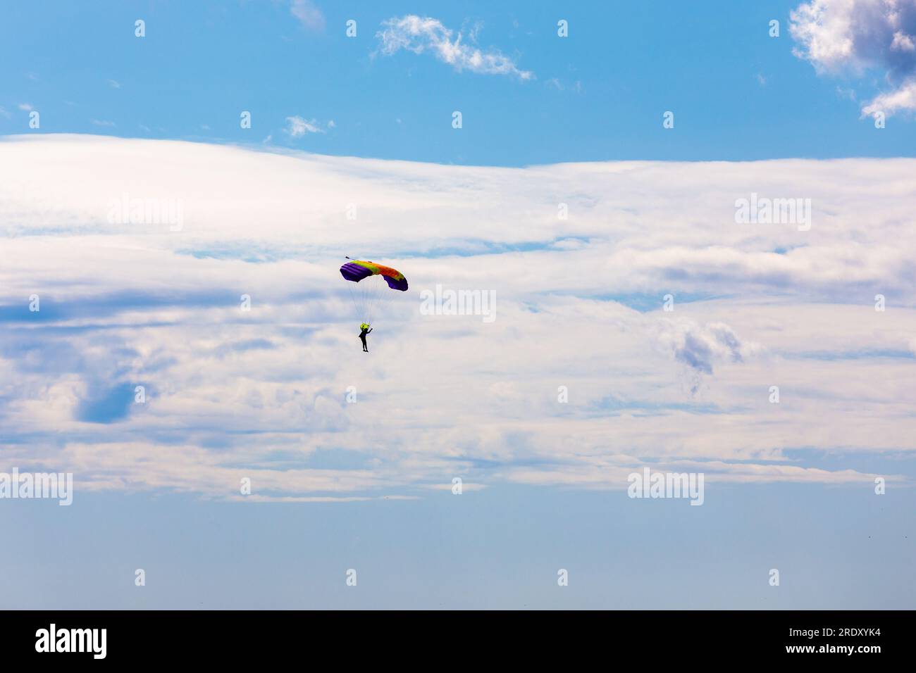 Parachute in the sky. Skydiver is flying a parachute in the blue sky ...