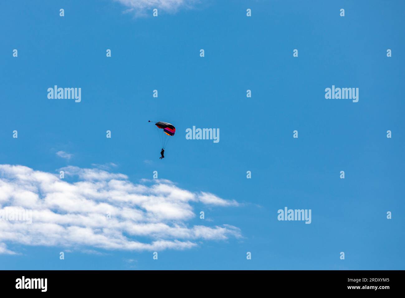 Parachute in the sky. Skydiver is flying a parachute in the blue sky ...