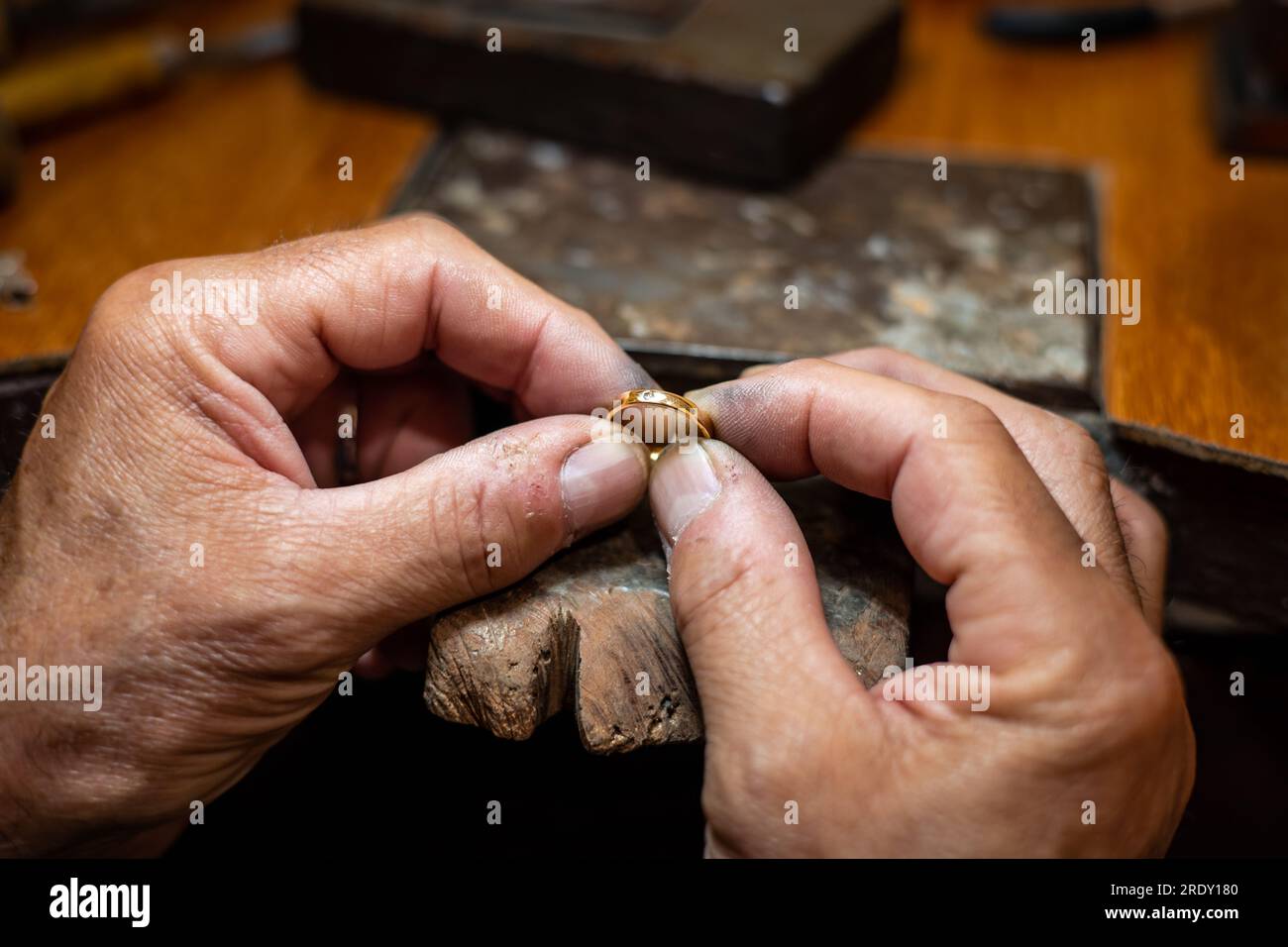 Goldsmith man working in his crafting jewelry workshop repairing and ...