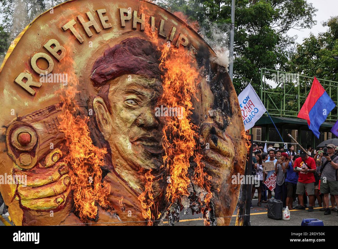 Protesters burn a two-faced gold coin effigy of President Ferdinand ...