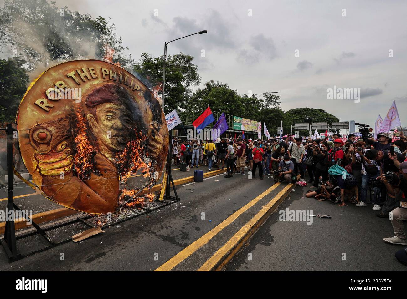 Protesters burn a two-faced gold coin effigy of President Ferdinand ...