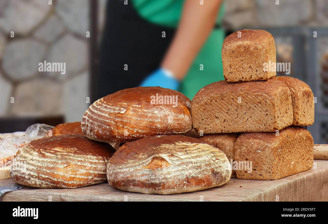 Large loaves of sourdough bread and cubes of rye bread at bakery stand ...