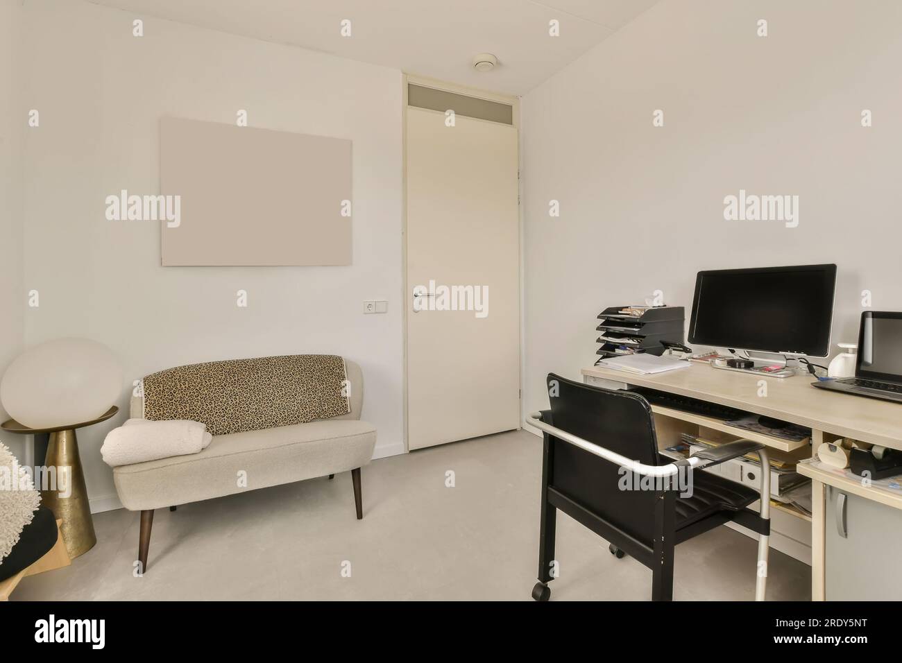 a home office with two computers on the desks and a leopard print chair ...