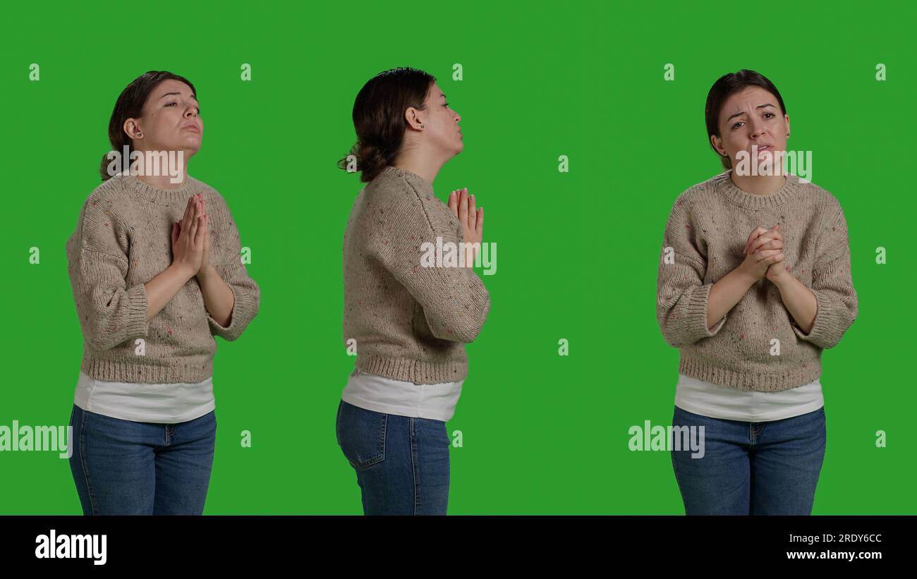 Religious spiritual girl posing with prayer hands sign in studio ...