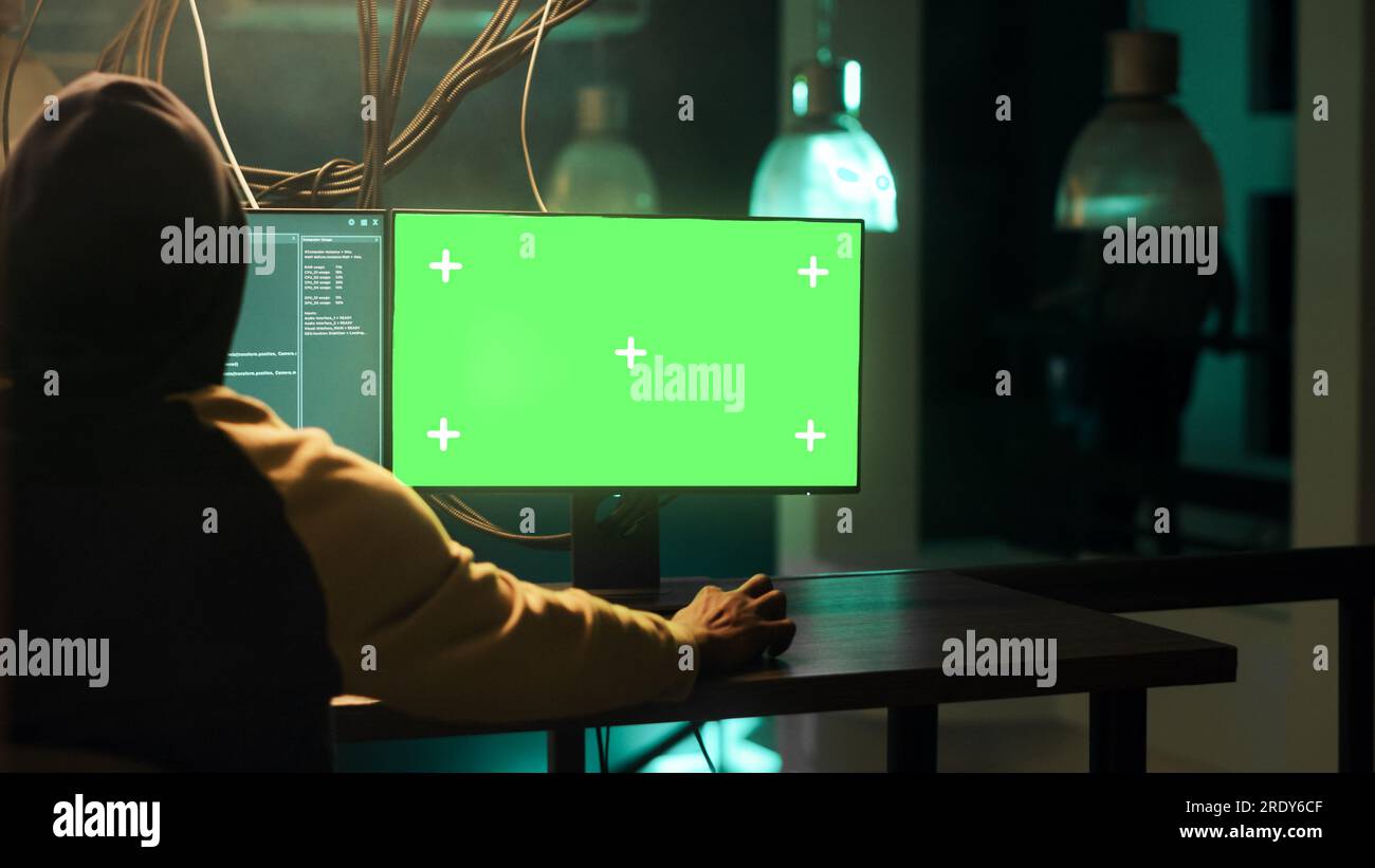 Male spy using computer display with greenscreen while stealing ...
