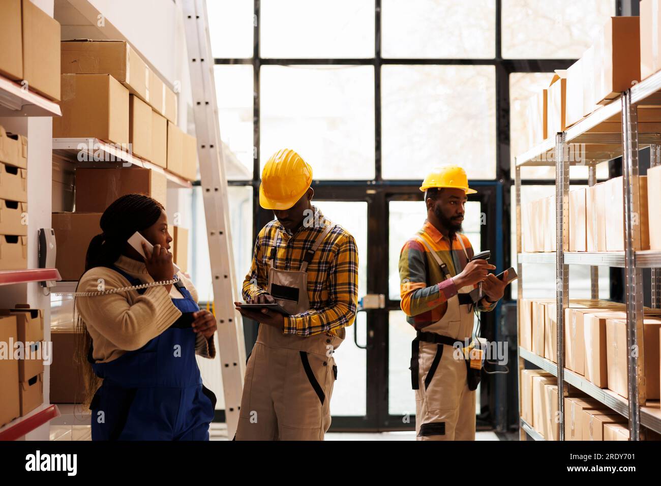 African american warehouse operator talking on landline phone about ...