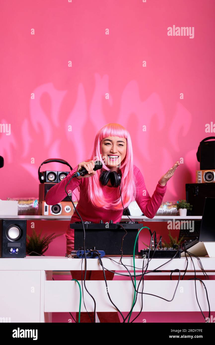 Musician standing at dj table holding microphone talking with fans ...