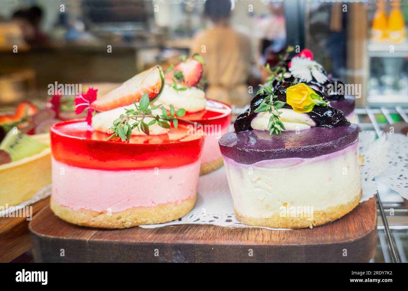 Strawberry and blueberry cheese cakes on display at a café ...