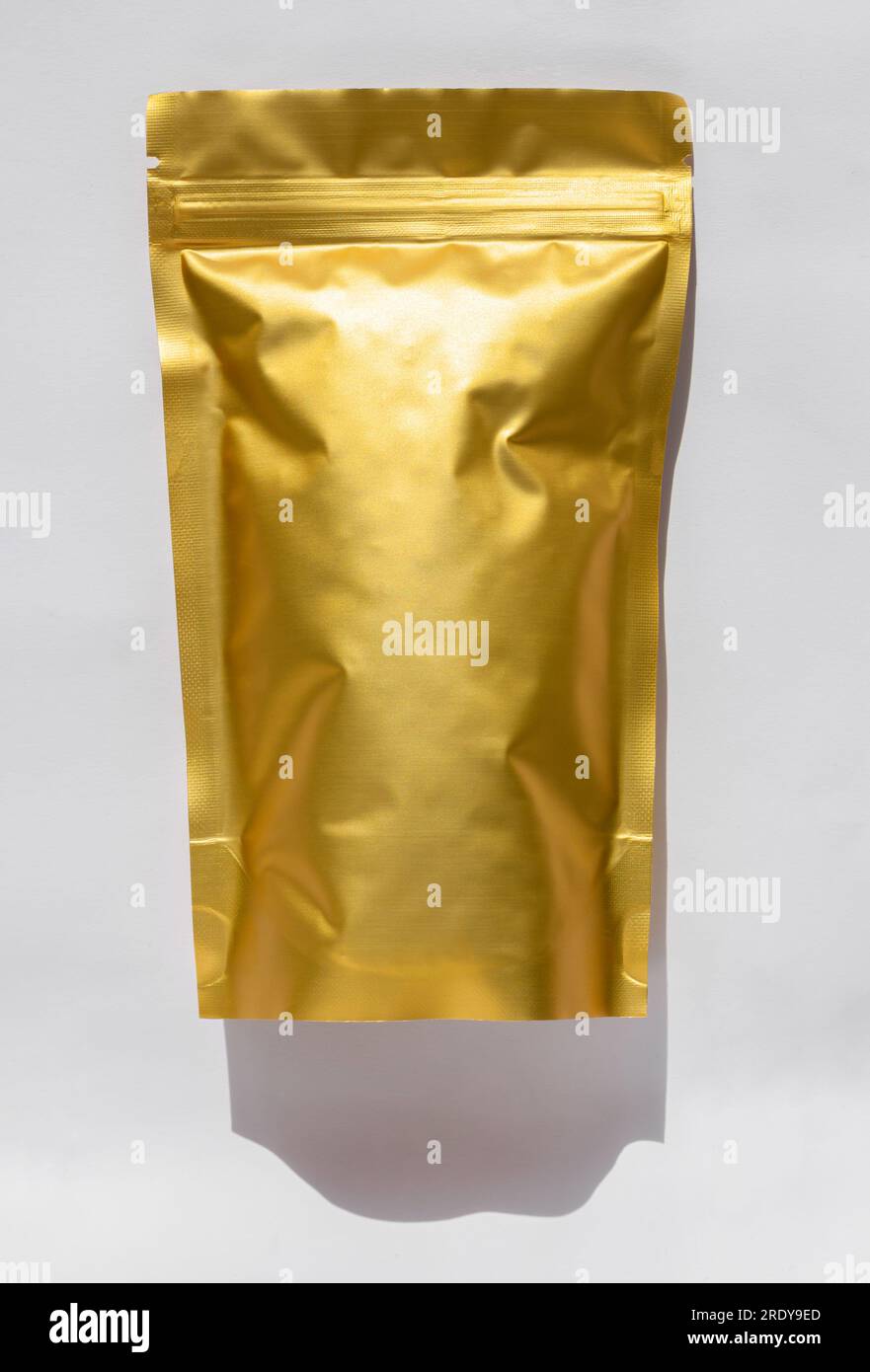 Golden metalized pouch bag with coffee beans top view with shadow ...