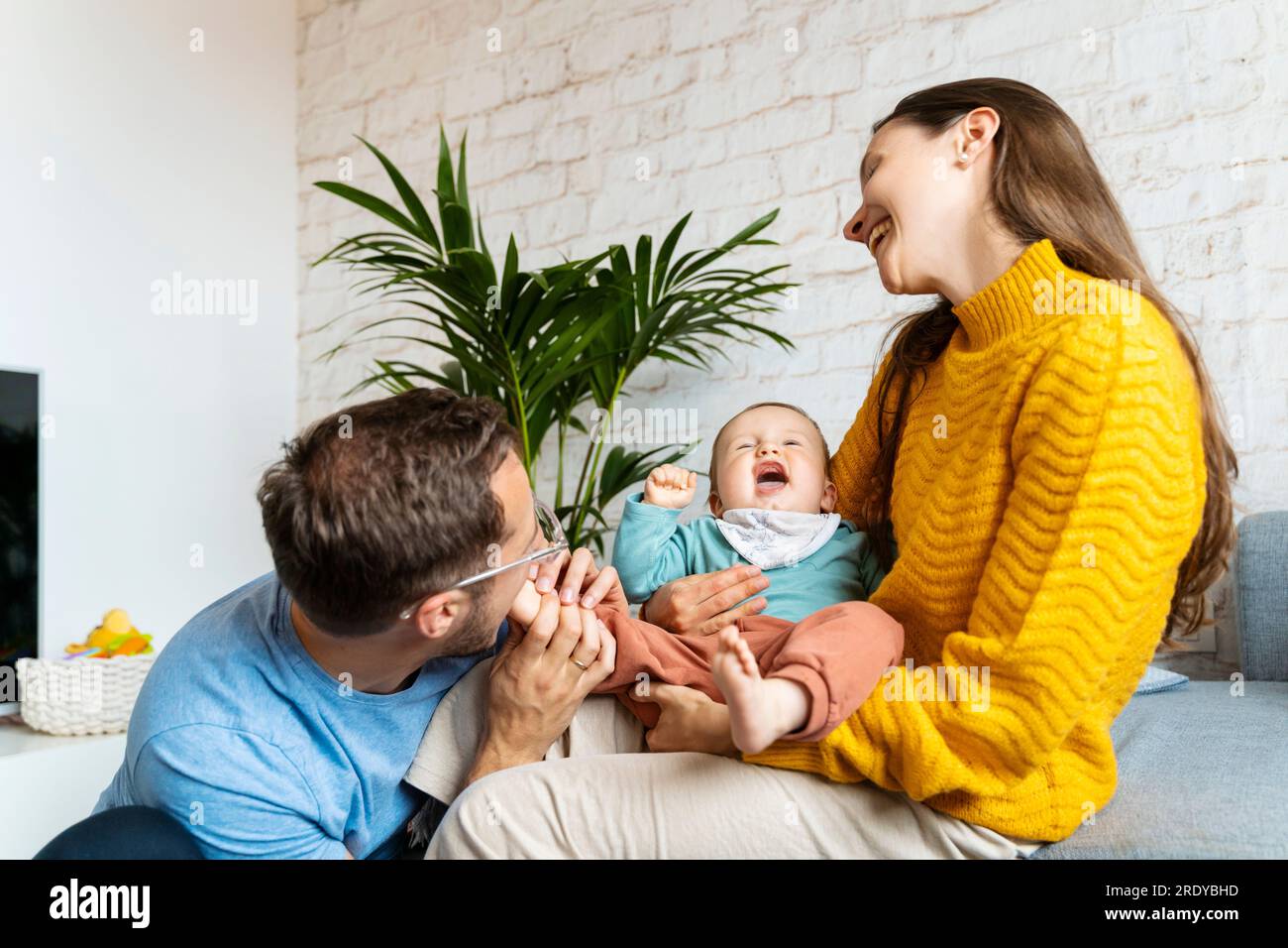 Playful parents spending leisure time with baby boy in living room ...