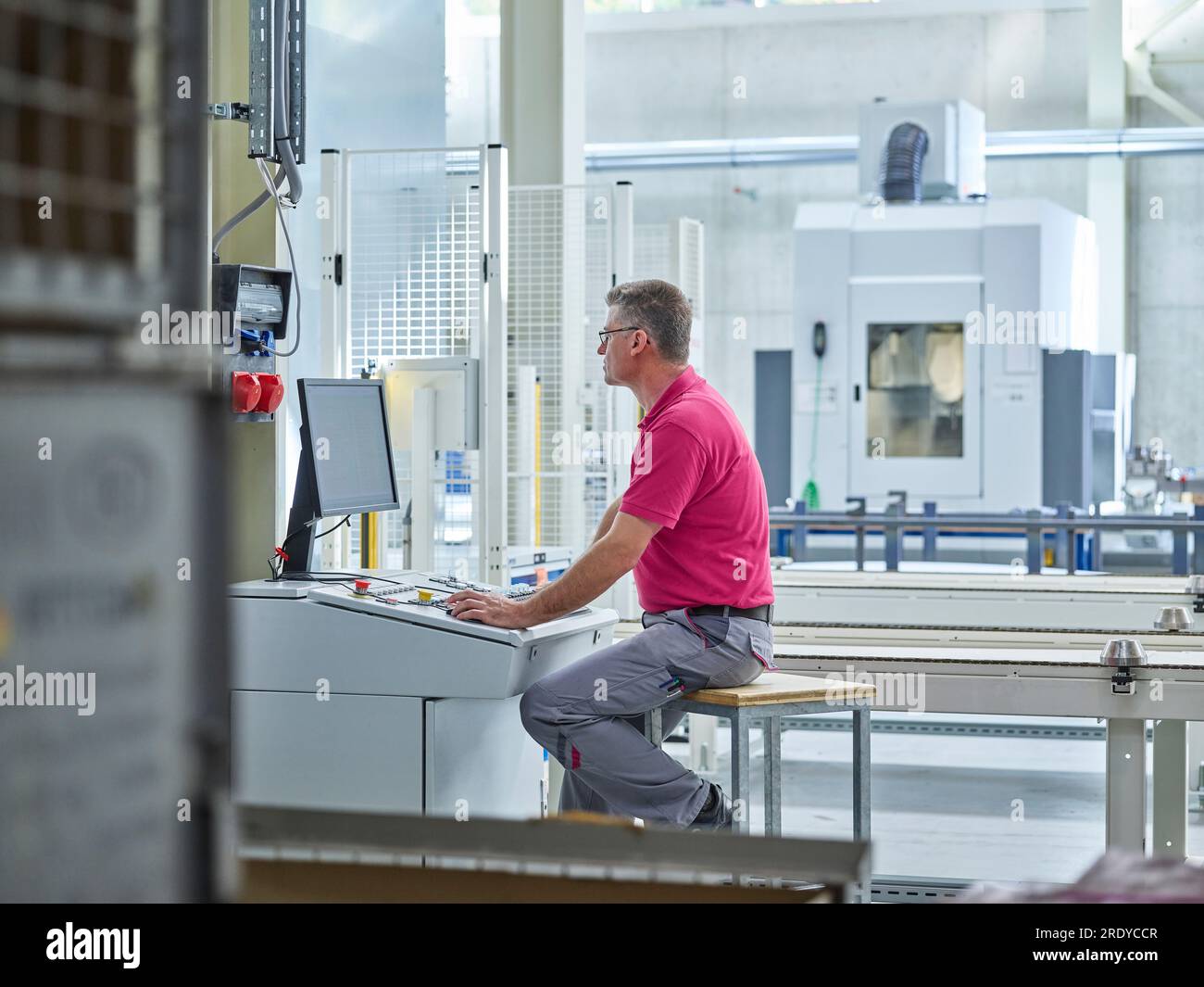 Engineer sitting and using computer in production factory Stock Photo ...