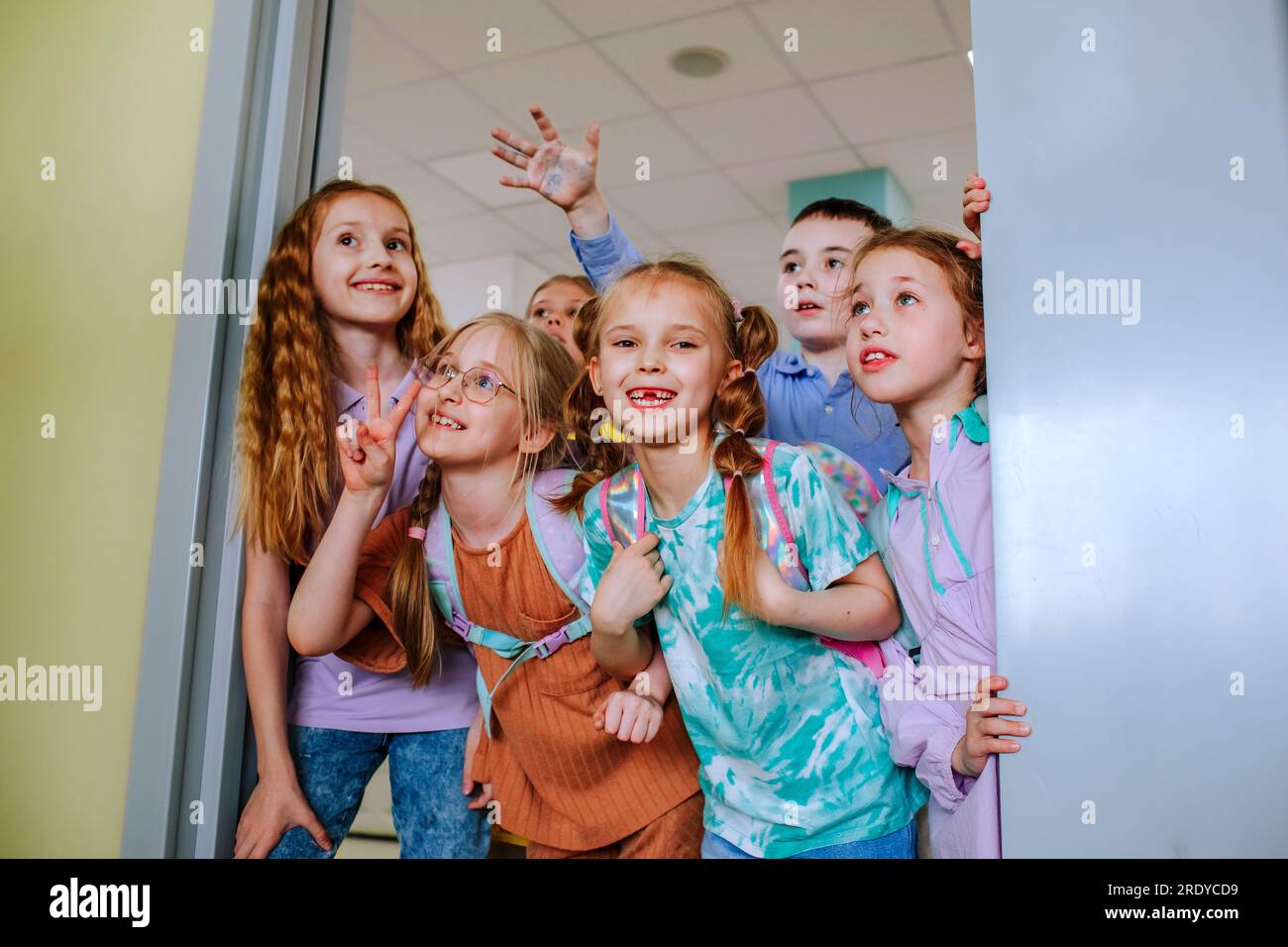 Cheerful school children gesturing in classroom door Stock Photo - Alamy