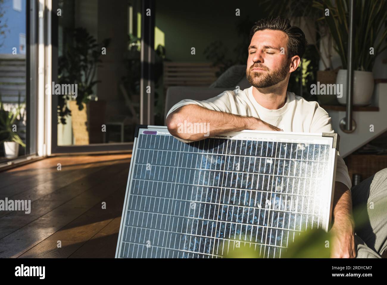 Freelancer sitting with eyes closed and solar panel at home Stock Photo ...