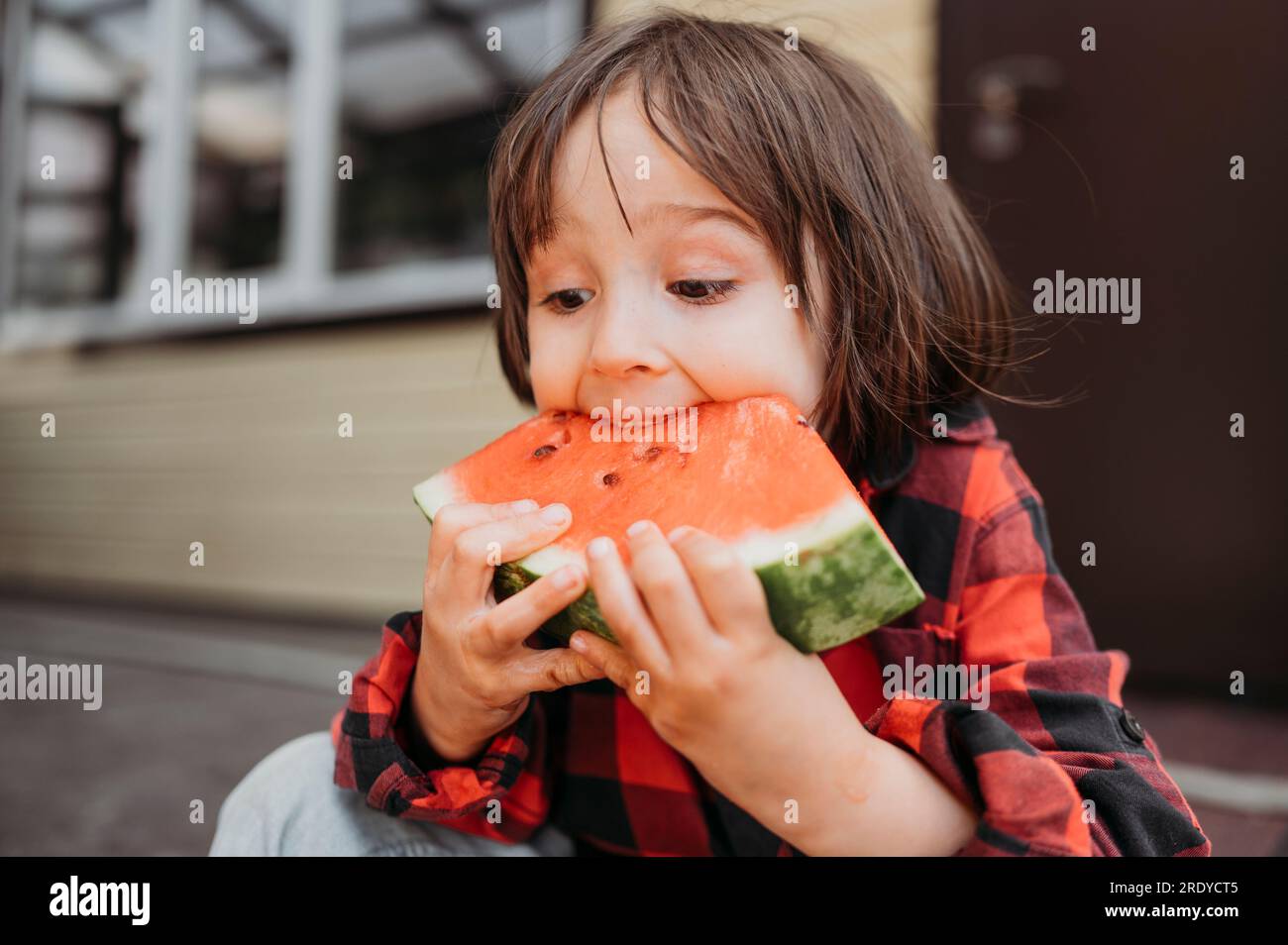 Boy eating watermelon slice Stock Photo - Alamy