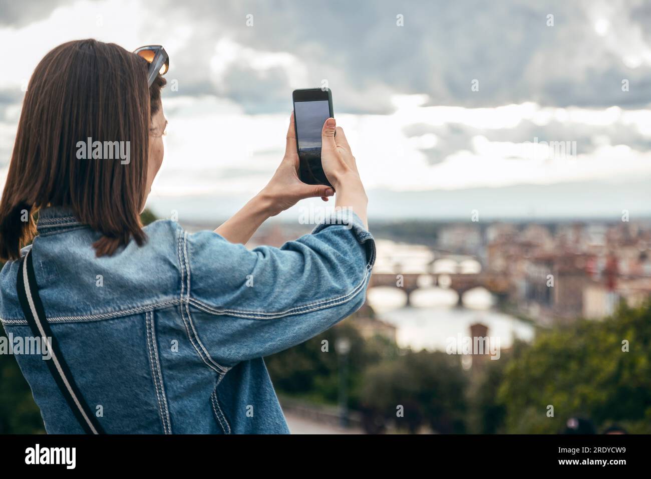 Woman photographing city through smart phone Stock Photo - Alamy
