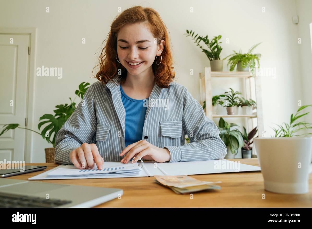 Happy young woman calculating financial graph at home Stock Photo - Alamy