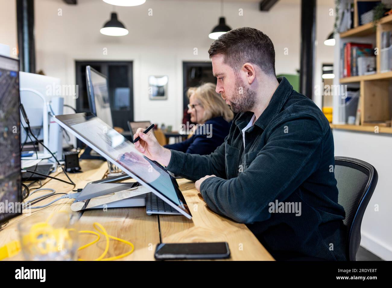 Architect working on graphics tablet at desk Stock Photo - Alamy