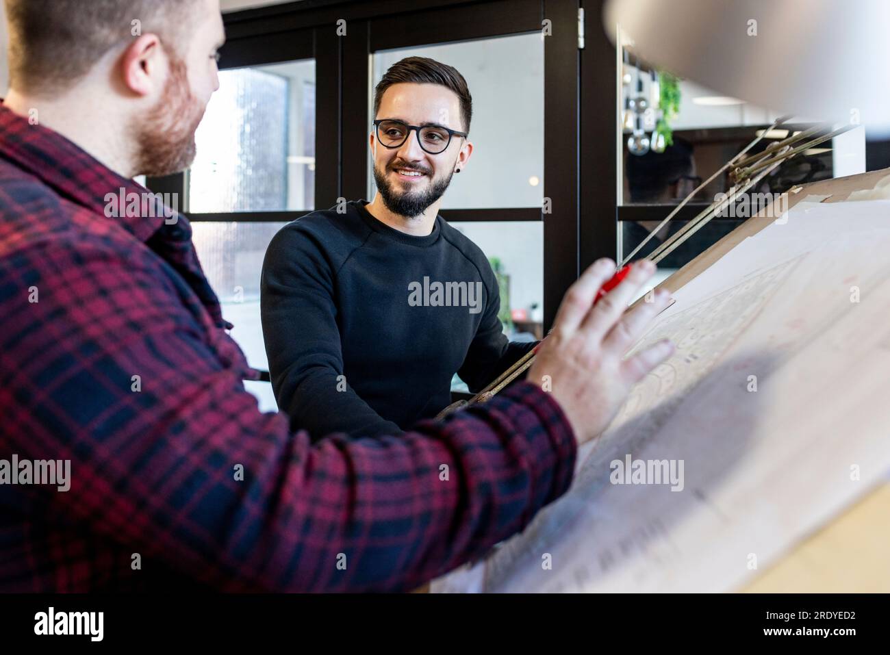 Happy architects working on blueprint in office Stock Photo - Alamy