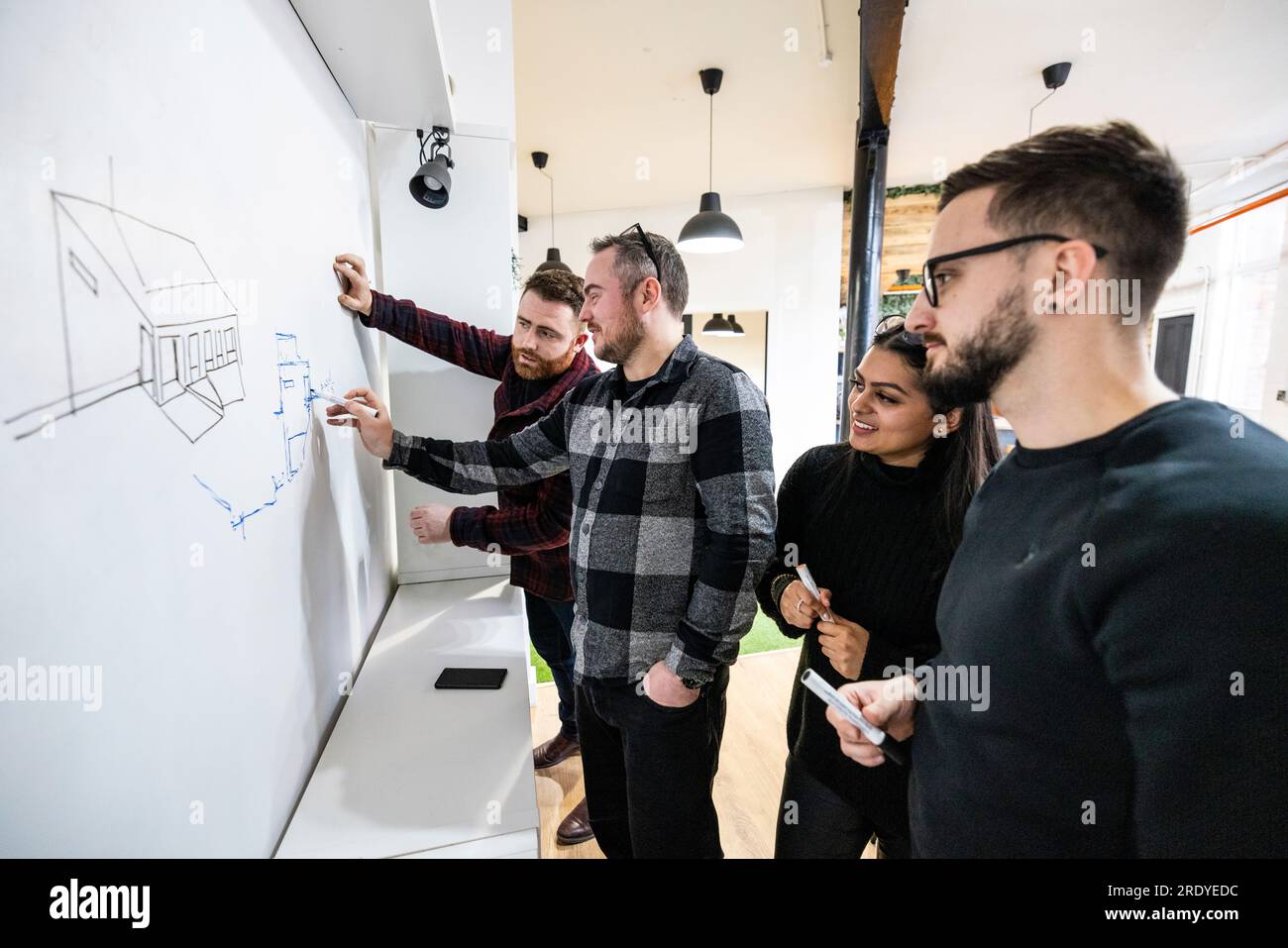 Architect drawing on white board with colleagues in office Stock Photo ...