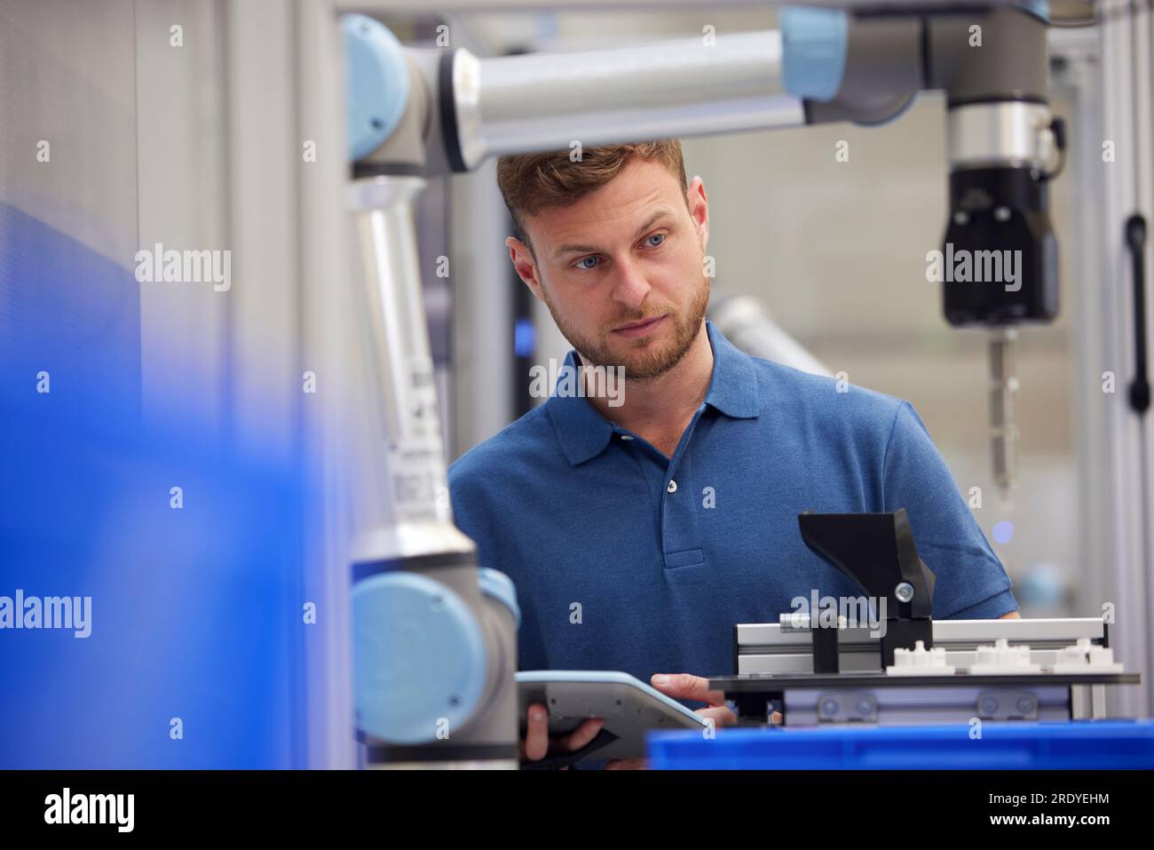 Focused engineer examining robotic machine in industry Stock Photo - Alamy